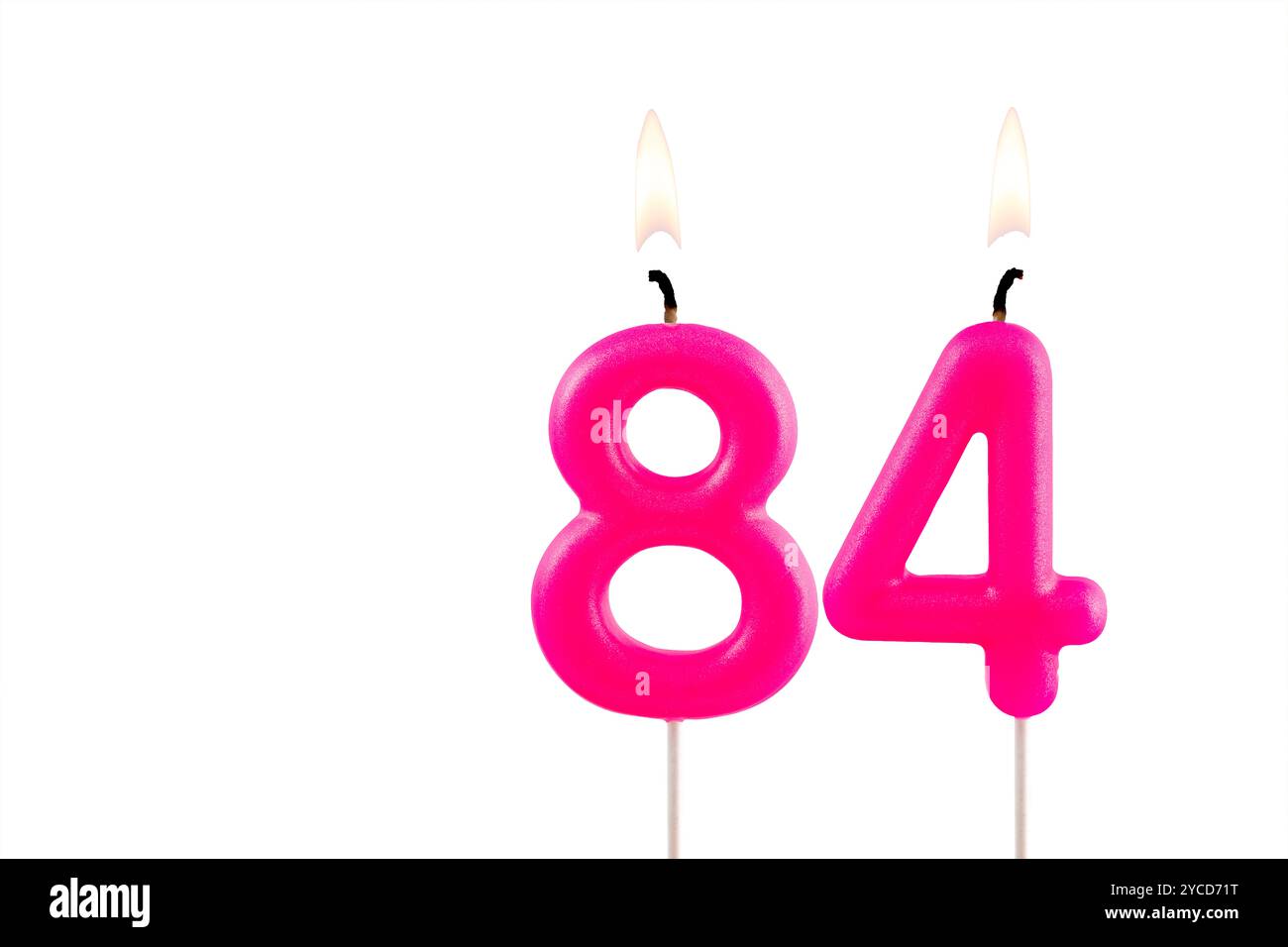 Pink number 84 birthday candle lit on white background Stock Photo - Alamy