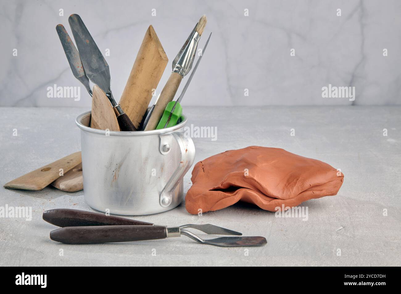 mug with many tools for sculpting and modeling and pieces of clay and ...