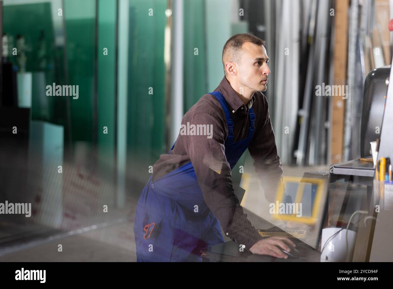 Glass processing factory worker operating CNC machine Stock Photo - Alamy