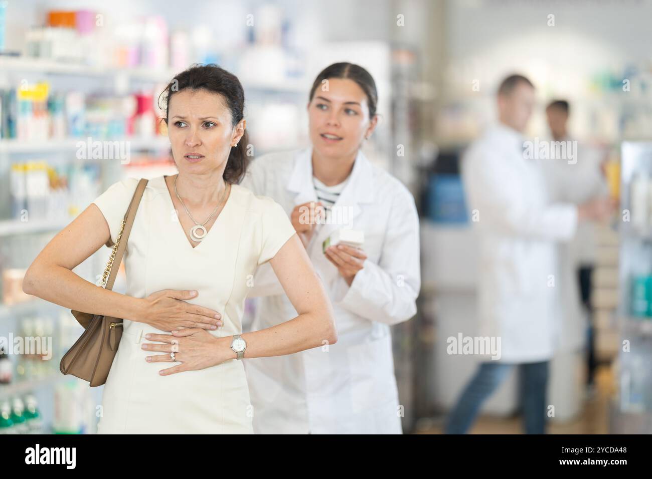 Female pharmacist advises medicine for stomach pain Stock Photo - Alamy