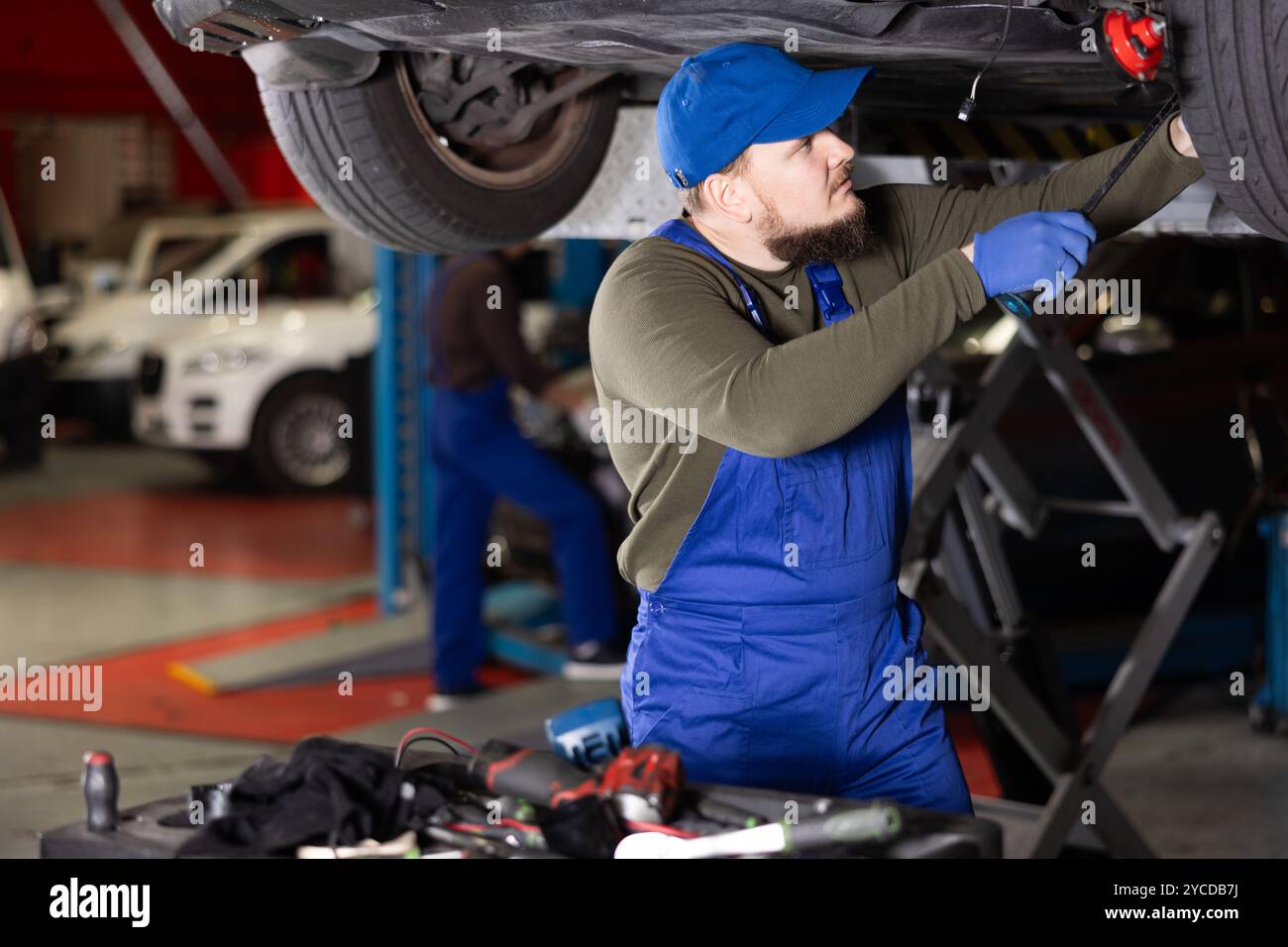 Mechanic is repairing a car - replacing the wheel ball joint of car ...