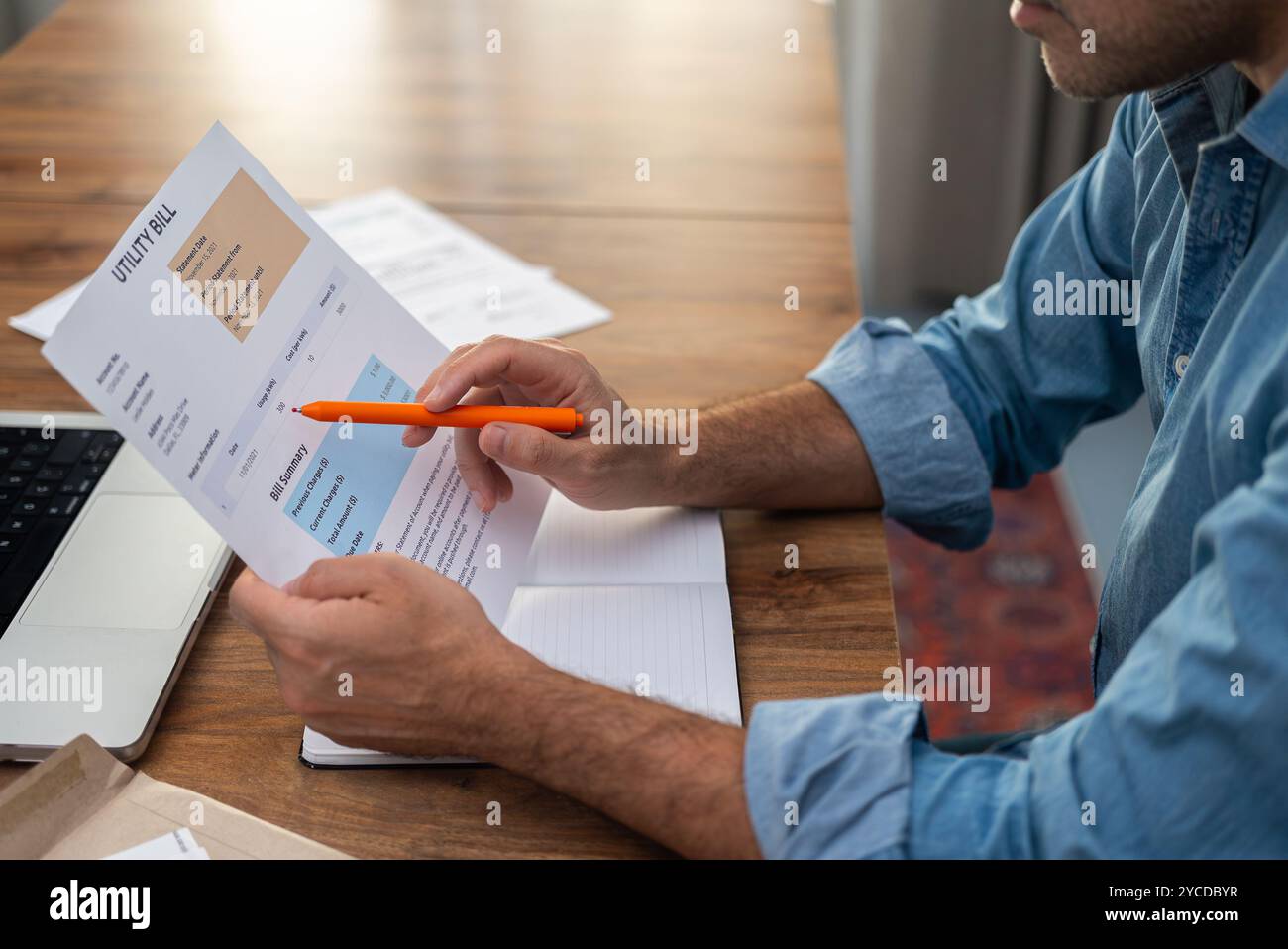 Male accountant checks utility bill pointing at printed graph at ...