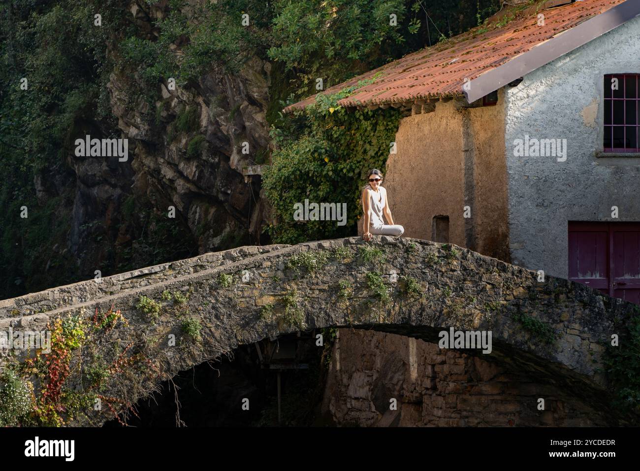 Tourist on the Ponte della Civera bridge in the village of Nesso on ...