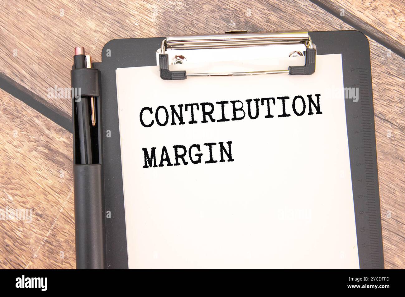 CONTRIBUTION MARGIN yellow notepad with text on the page. white pen ...