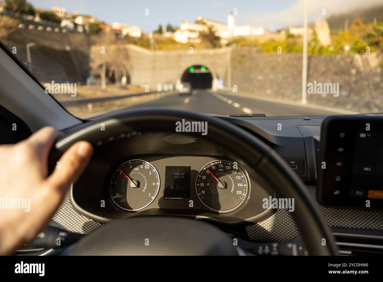 Driver view to the speedometer, with hand on the steering wheel ...