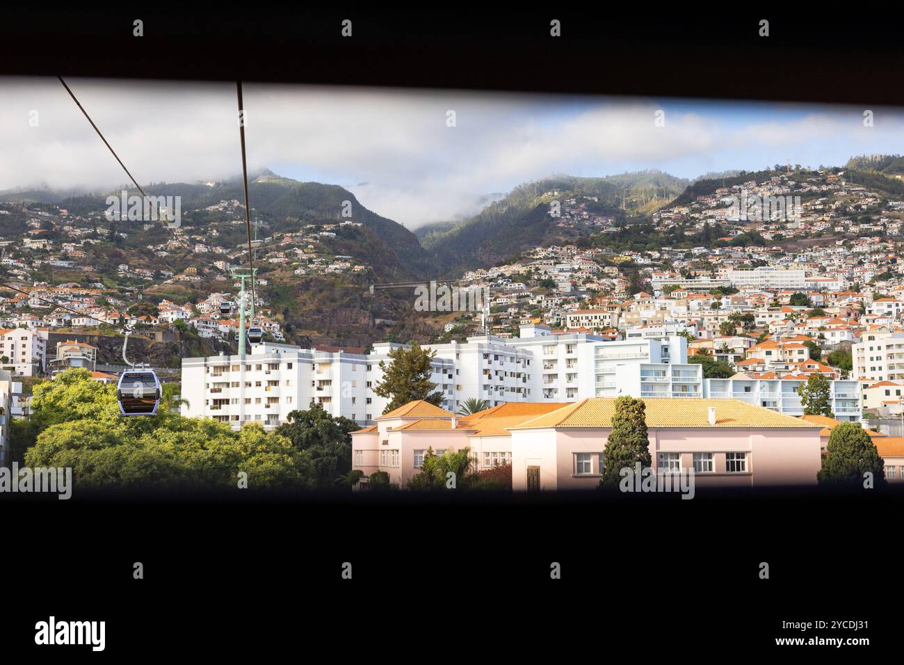 Cable car with cabins above cityscape of Funchal and Monte with the ...