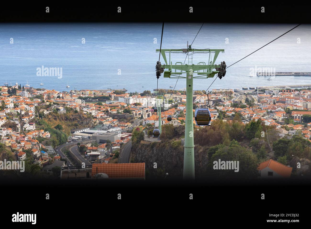 Cable car with cabins above city and sea in Funchal viewed from inside ...