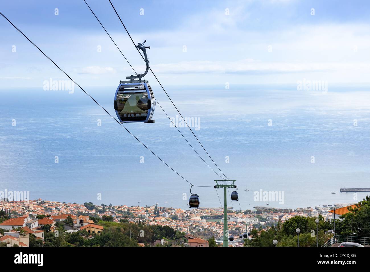 Cable car with cabins above city and sea in Funchal viewed from Monte ...
