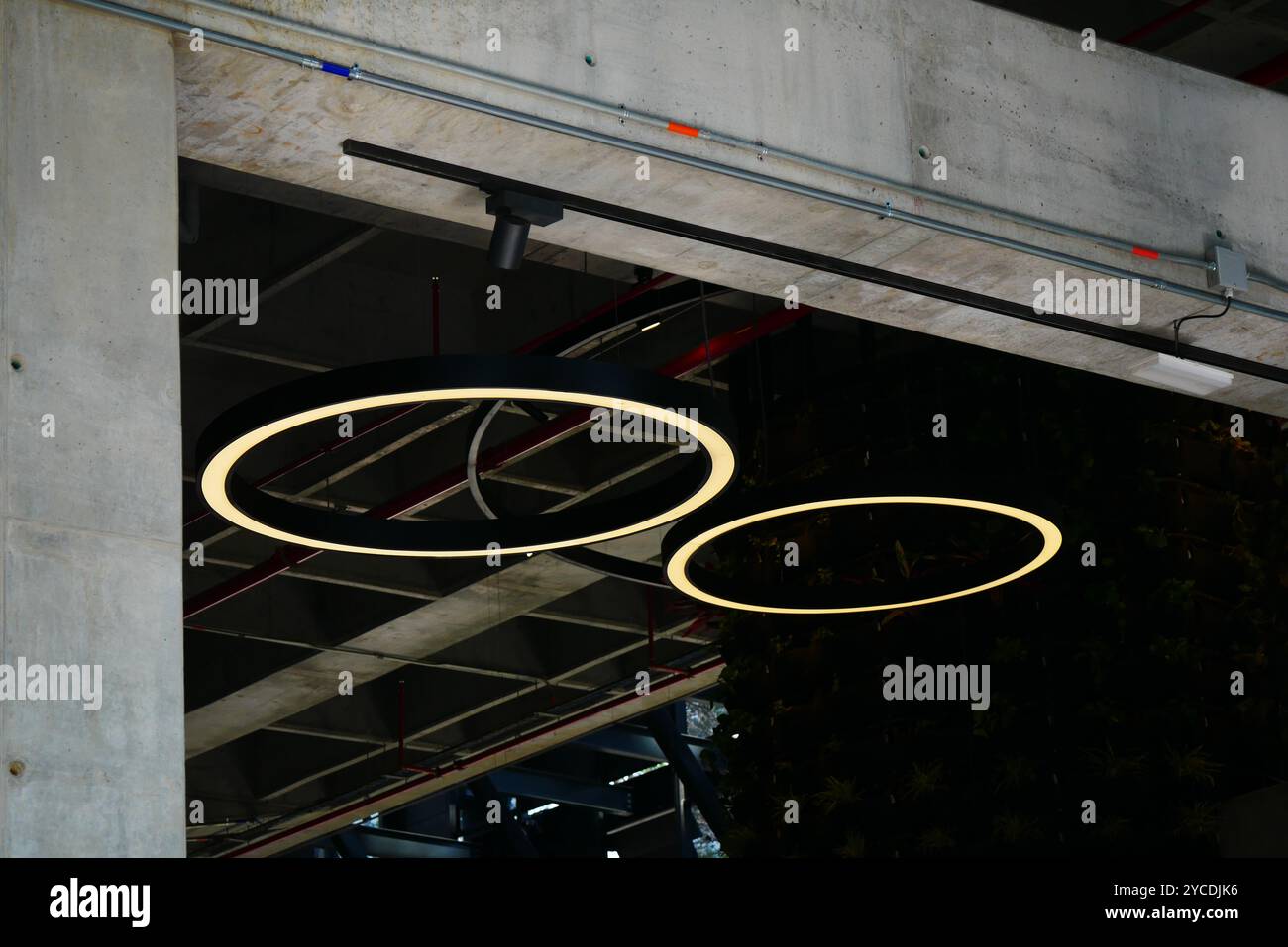 A modern architectural space featuring industrial-style hanging lamps ...