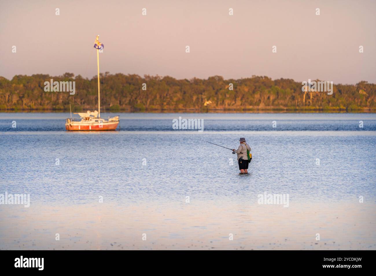 Fisherman standing in shallow water fishing, Carlo Point, Tin Can Bay ...