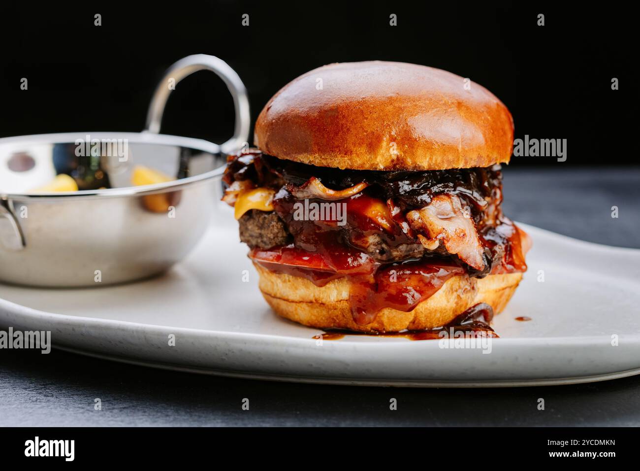 Gourmet BBQ bacon cheeseburger with crispy fries, perfect for indulgent ...