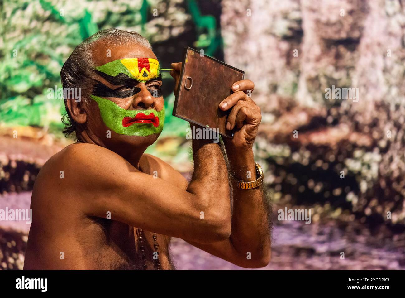 Kathakali exponent preparing for performance by applying face make-up ...
