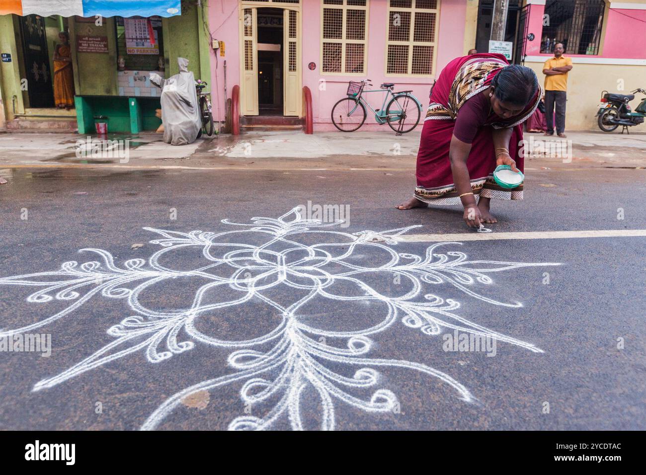 Indian woman drawing Kolam Rangoli - form of painting drawn by using ...