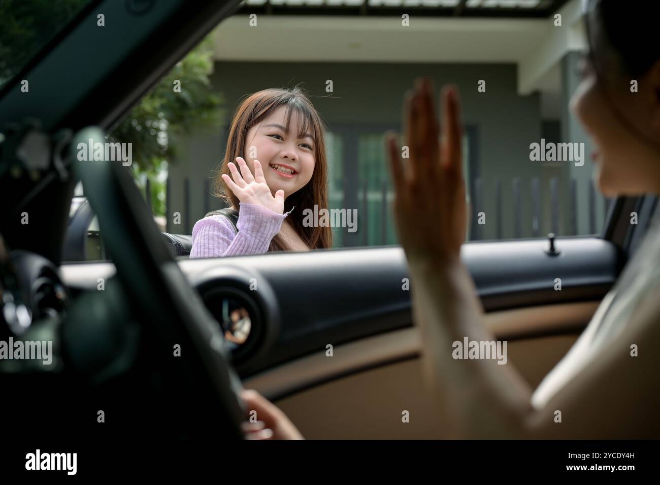 A young, adorable Asian girl is saying goodbye to her mom before ...