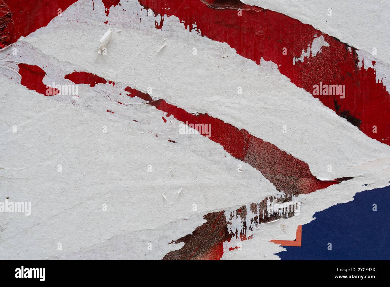 Peeled red paper poster on a wall Stock Photo - Alamy