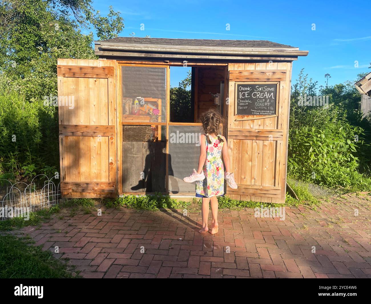 A little girl in a dress at the ice cream booth. At Tinder Hearth ...
