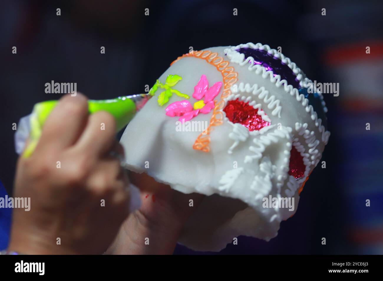 A member of the Flores family makes a traditional sugar skull ...