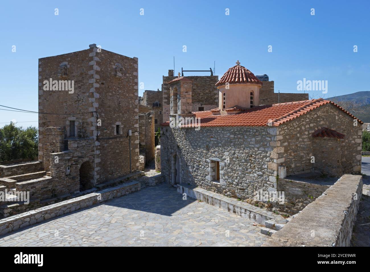 Traditional stone village buildings with red tiled roof under a blue ...