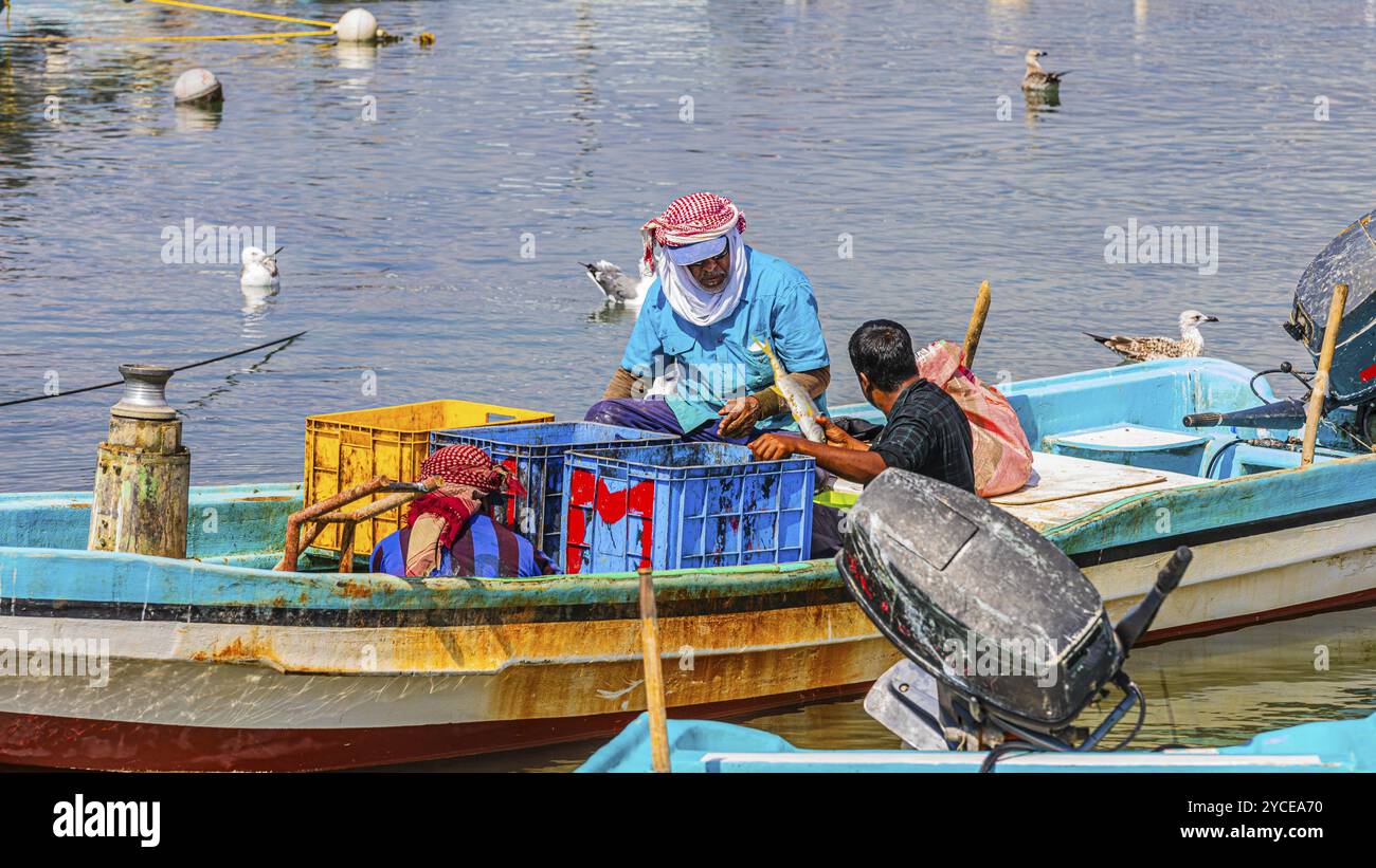 Fishermen working on their boats in the harbour of Mirbat, Dhofar ...