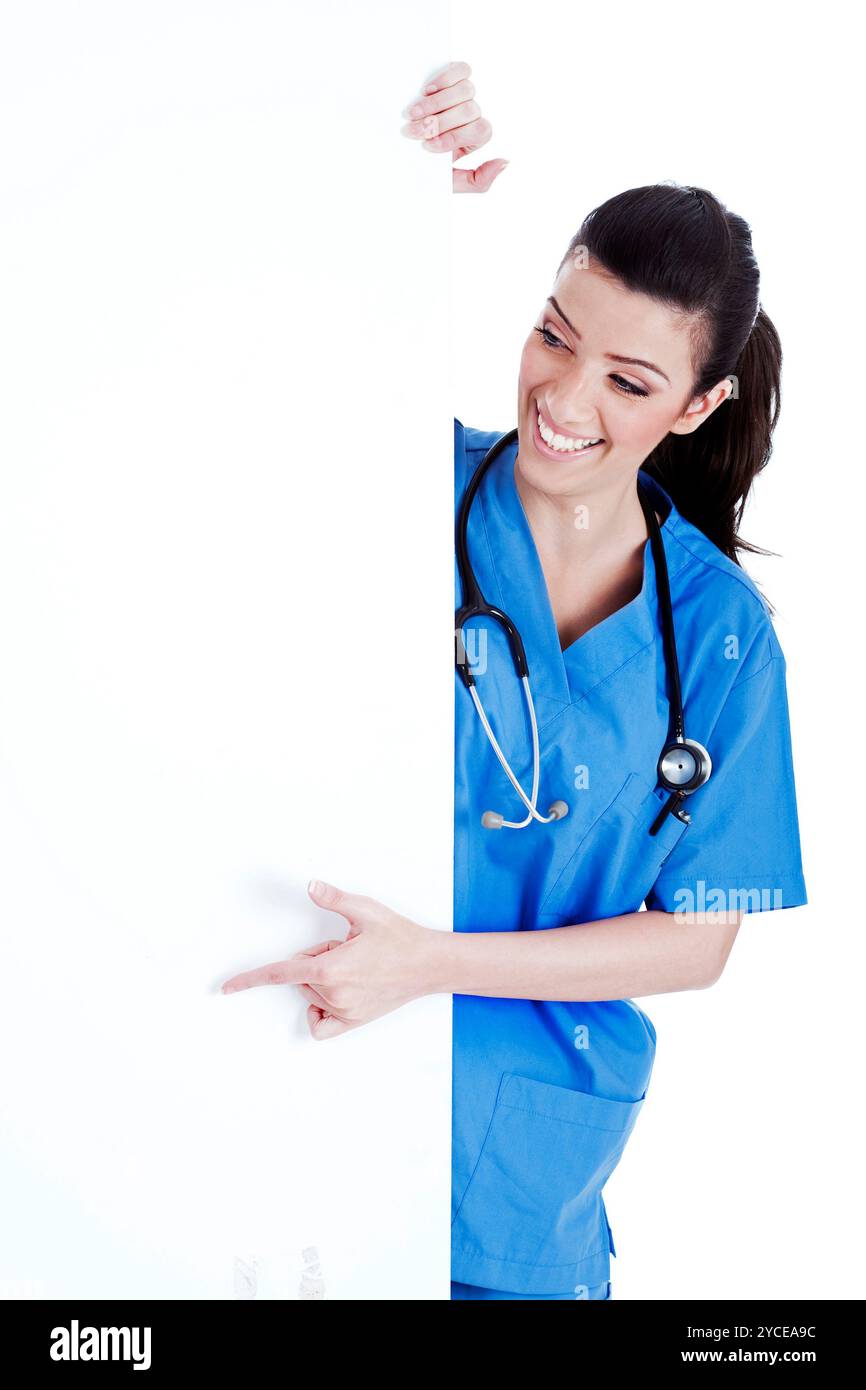 Portrait of female nurse standing behind the white board over white ...