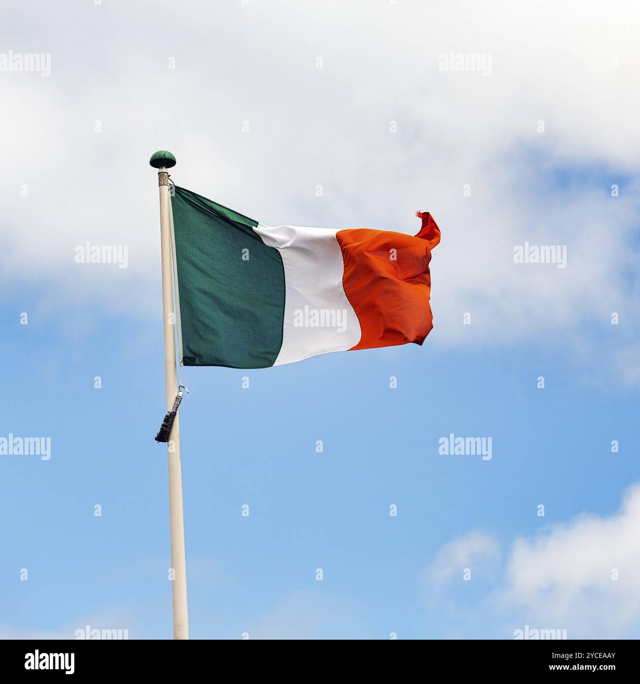 Irish national flag, tricolour waving against a slightly cloudy sky ...