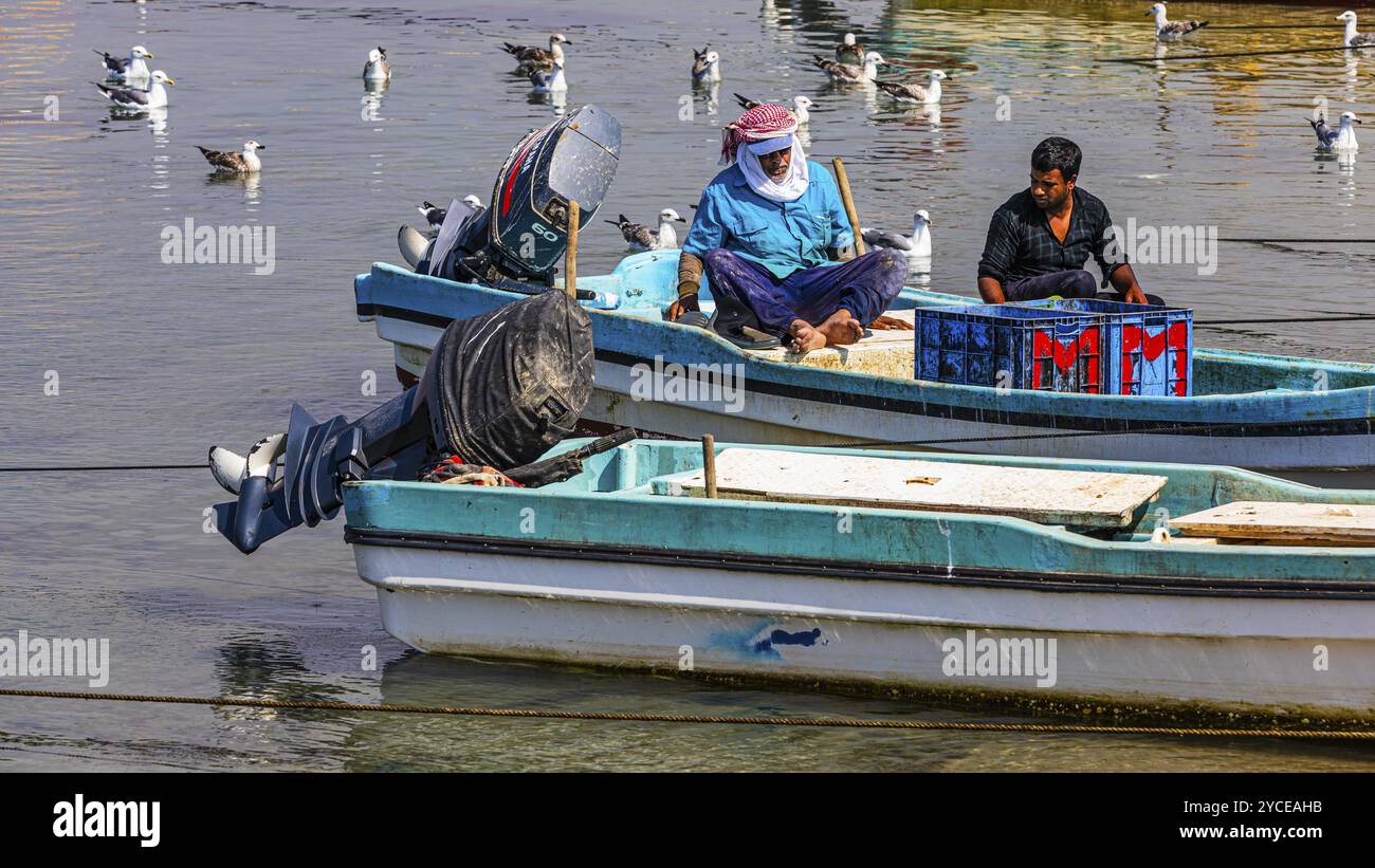 Fishermen working on their boats in the harbour of Mirbat, Dhofar ...