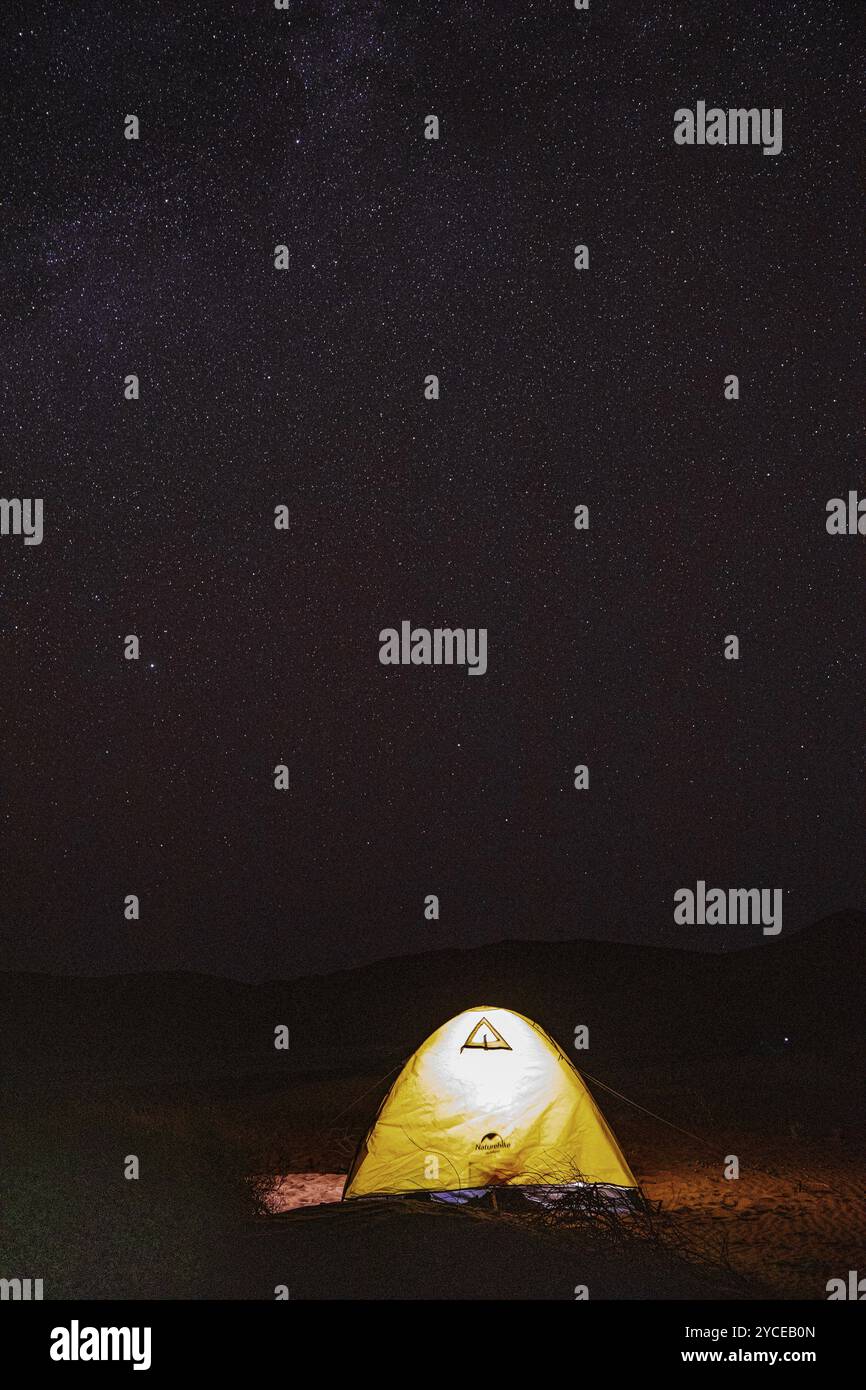 Starry sky at night, in front of it an illuminated tent, night shot ...