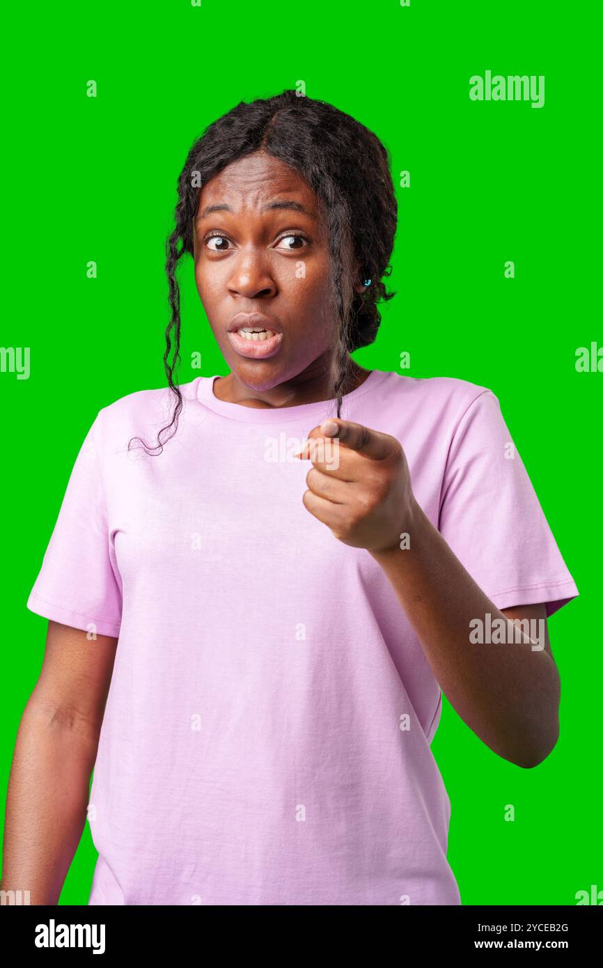 A surprised woman poses dramatically with hands on her chest in front ...