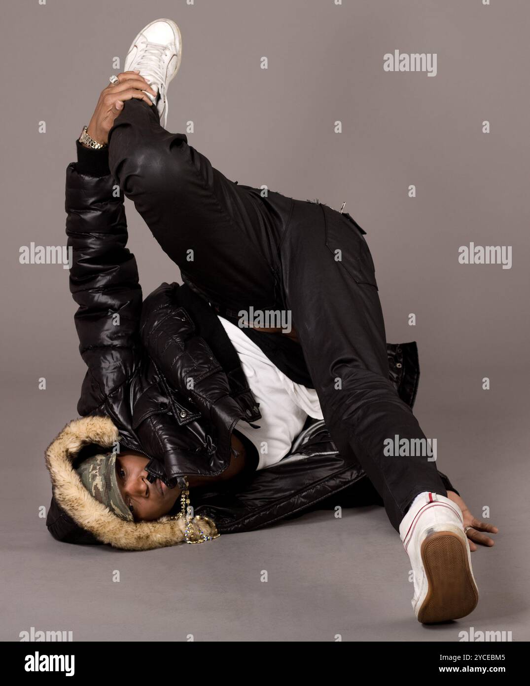 Black american performing floor movements in dance on grey background ...