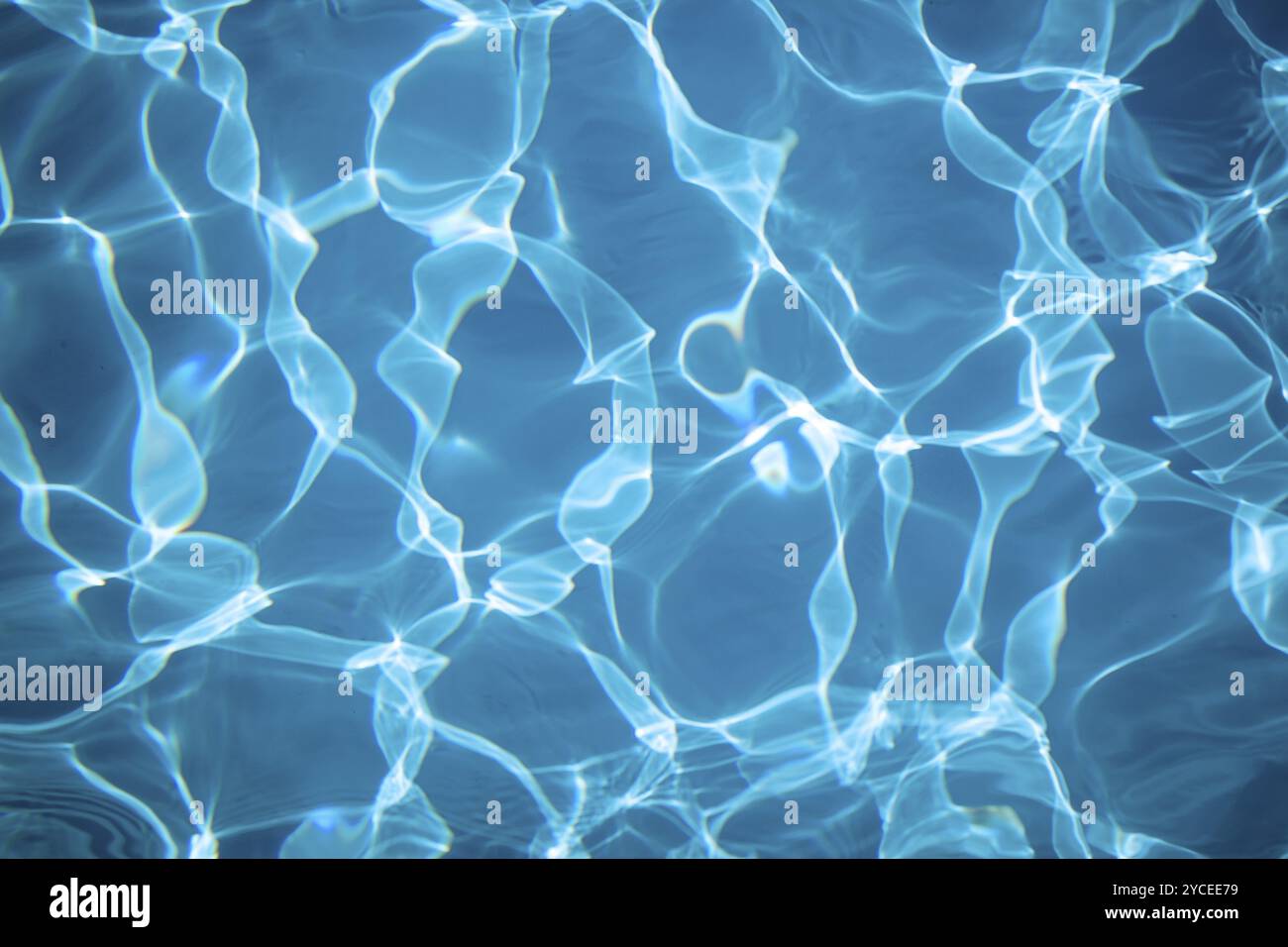 Reflection of sunlight in the water of a swimming pool with blue cast ...