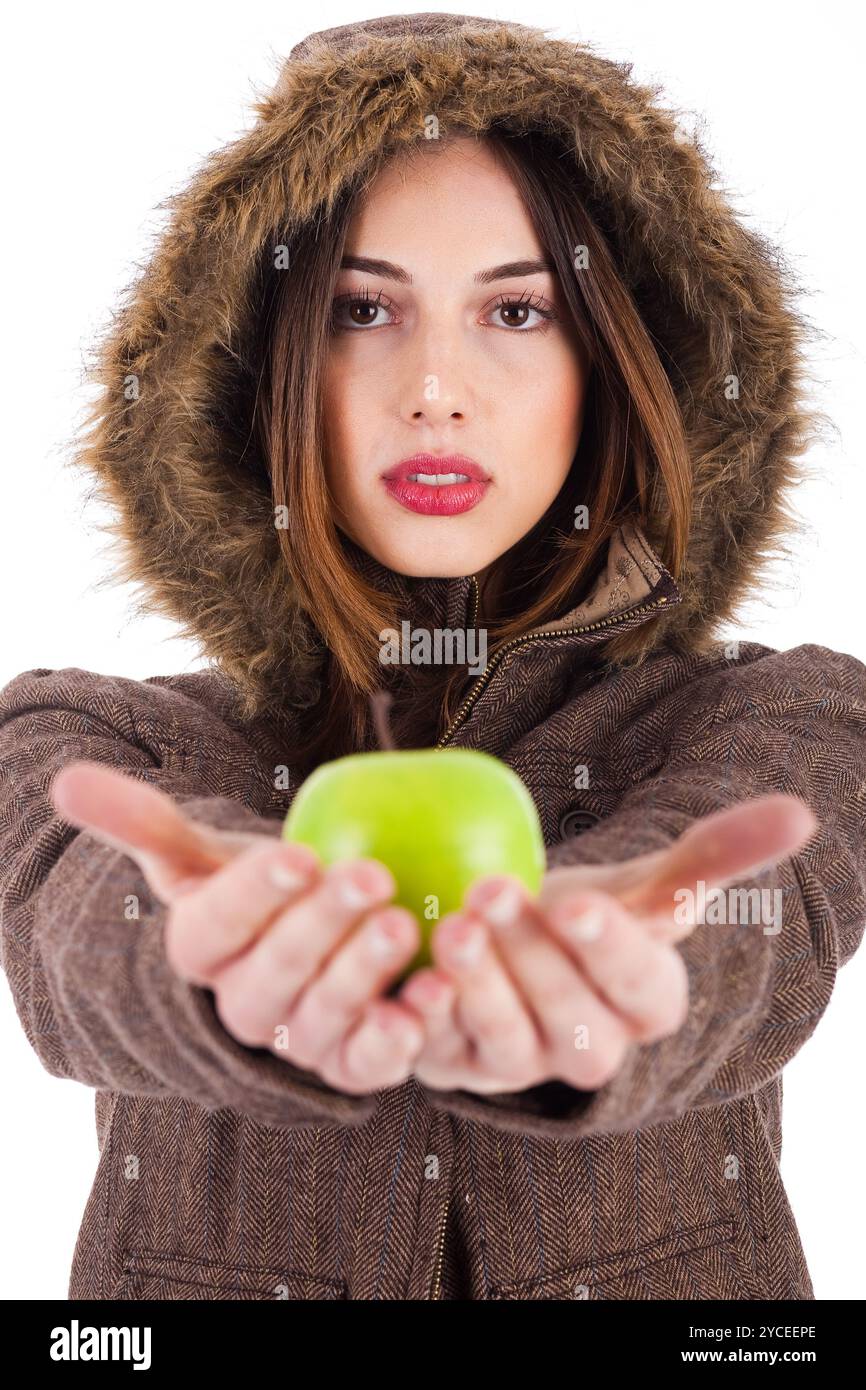 Beautiful young lady showing green apple wearing a fur coat with head ...