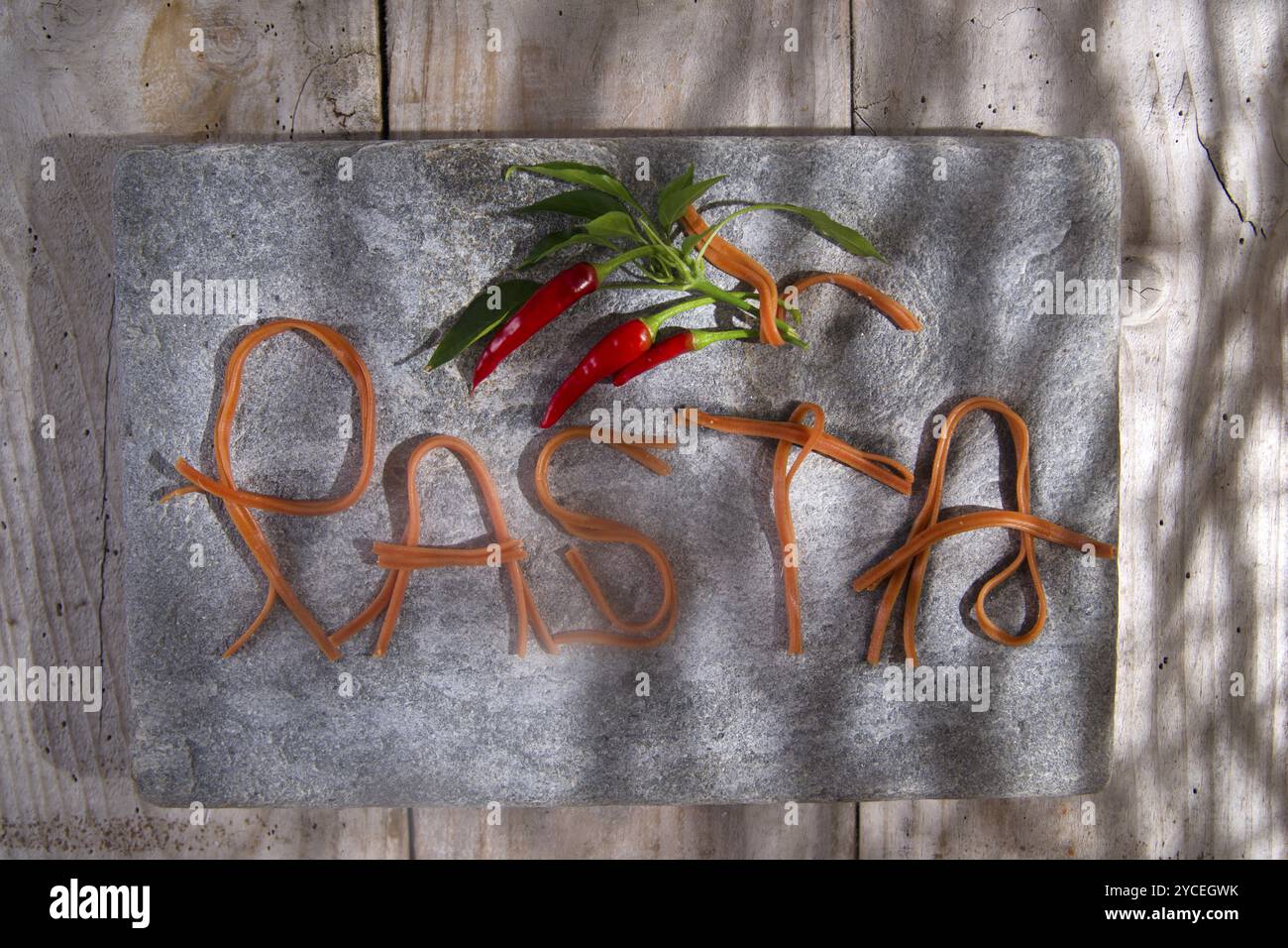 Use of spaghetti pasta on black stone to write for advertising Stock ...