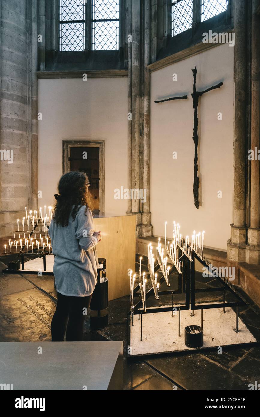 A young woman praying in a church. Vertical composition Stock Photo - Alamy