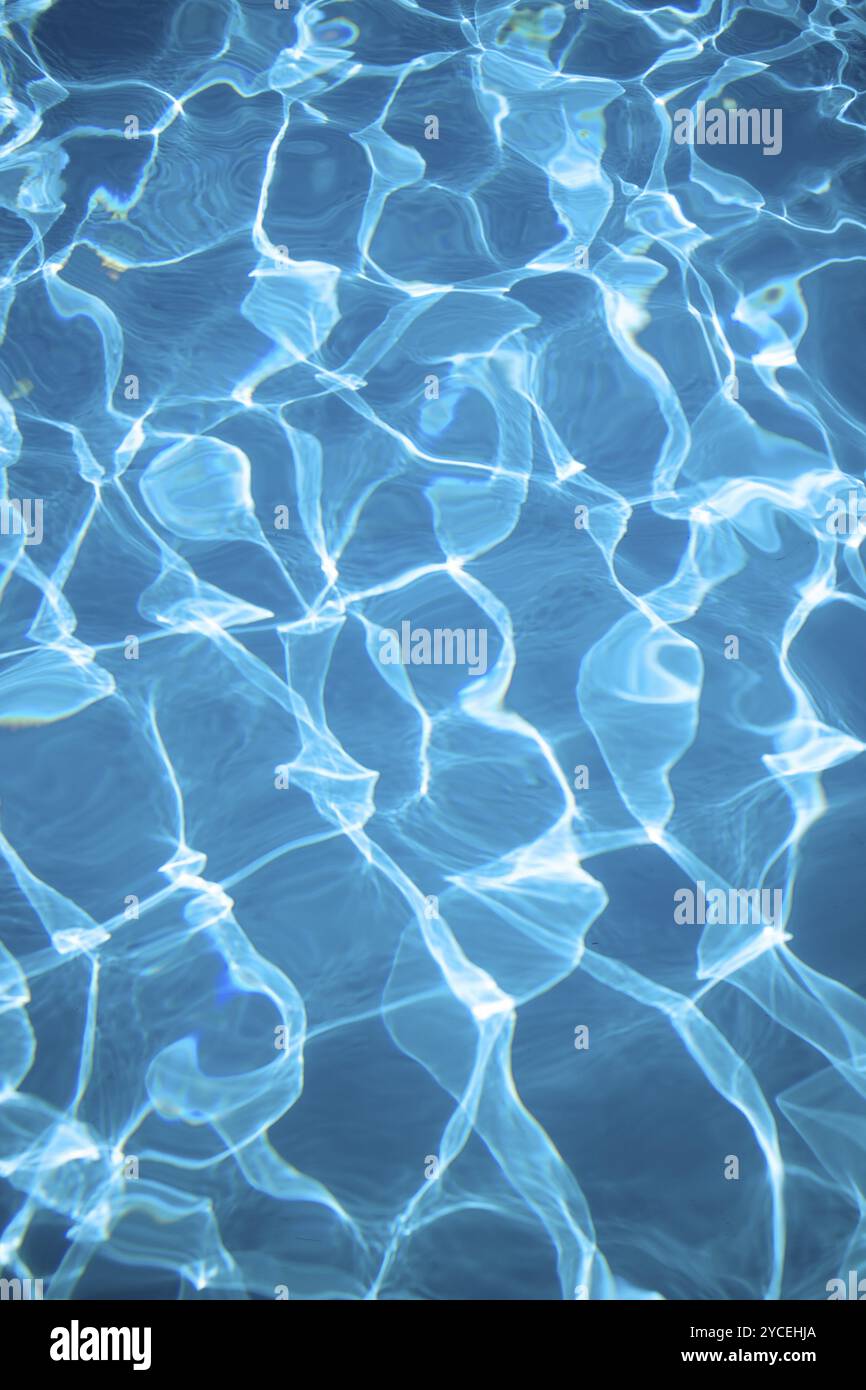 Reflection of sunlight in the water of a swimming pool with blue cast ...