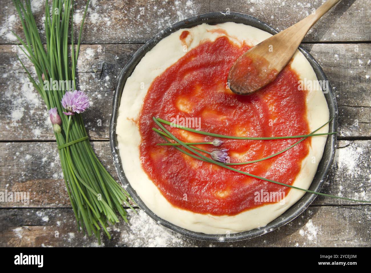 Preparing pizza made with tomato and chives Stock Photo - Alamy
