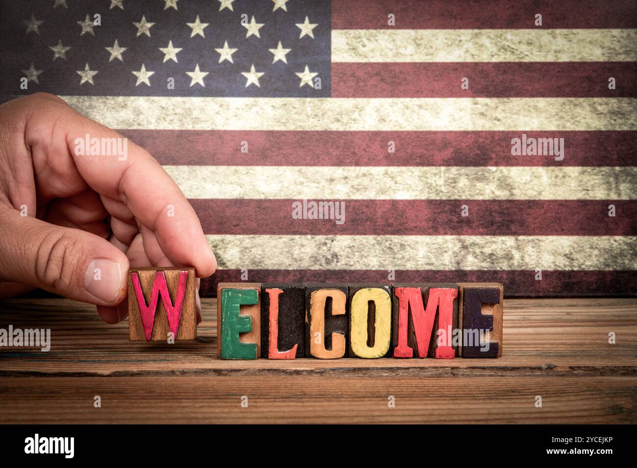 Welcome. Colorful letters of the alphabet on a wooden texture table ...