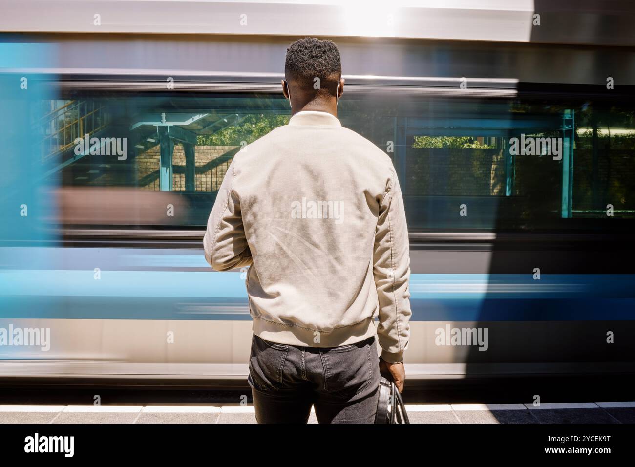 Back, black man and train with luggage for commute, urban travel and ...