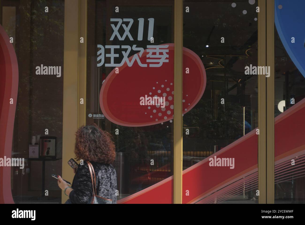 HANGZHOU, CHINA - OCTOBER 23, 2024 - Customers walk past a sign for the ...