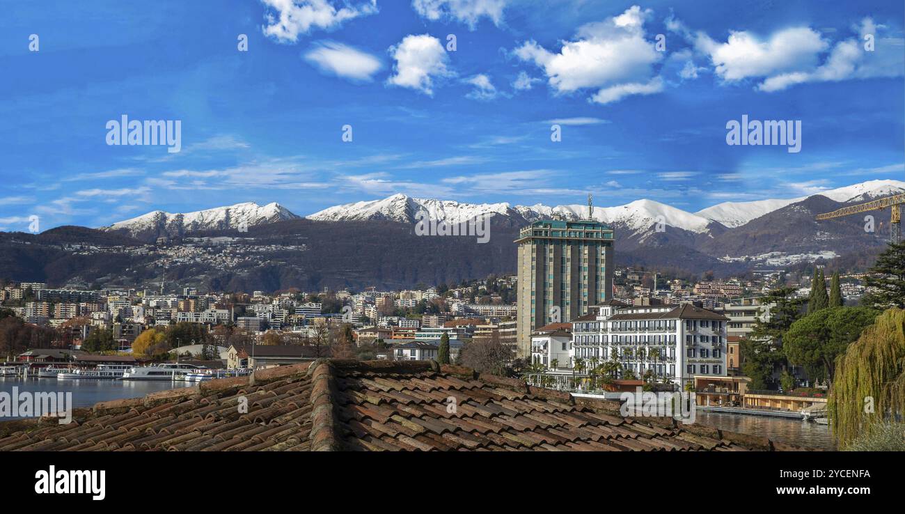 Day winter view on Lugano town and snow-capped mountains behind and ...