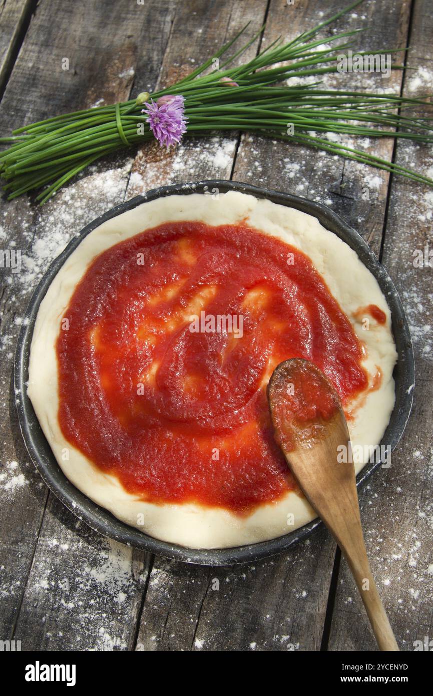Preparing pizza made with tomato and chives Stock Photo - Alamy