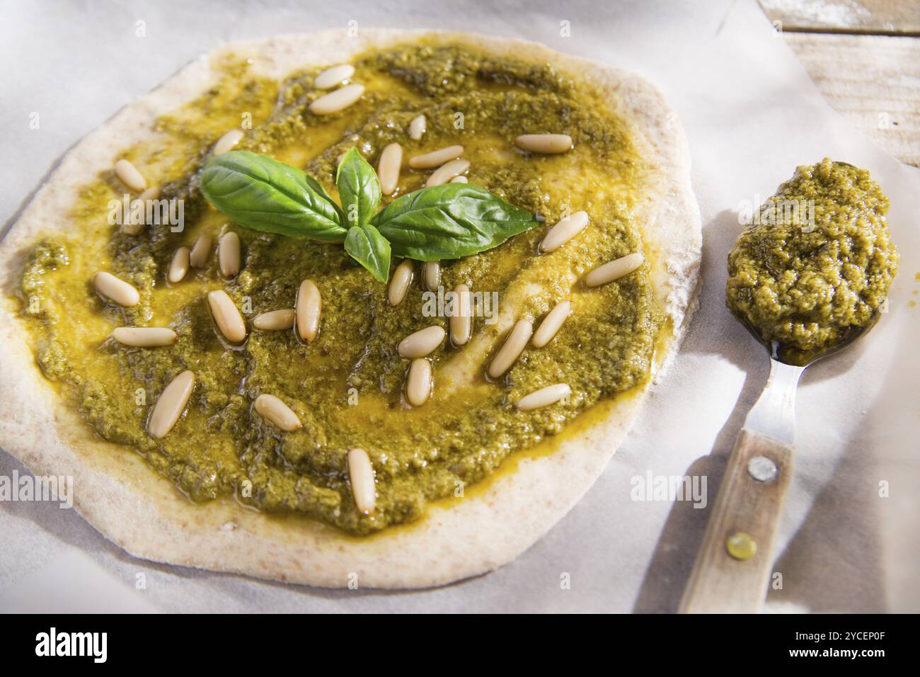 Preparation of uncooked pizza with pesto sauce Stock Photo - Alamy