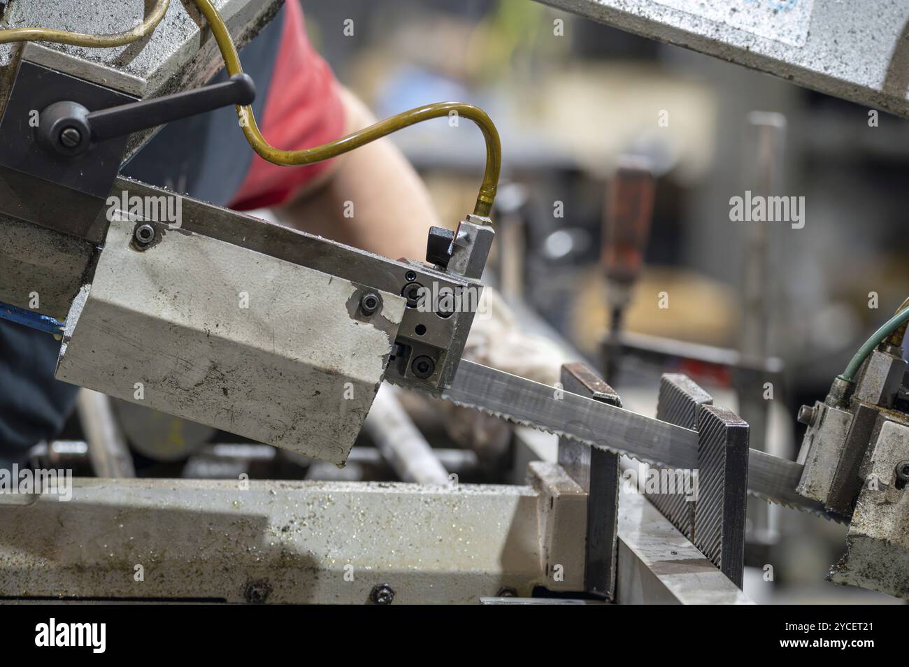 Automatic band saw machine cutting the metal rod with water base ...