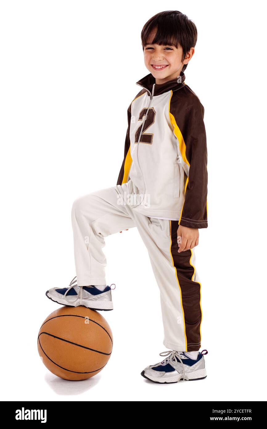 Cute junior boy basket ball player leg over the ball on isolate white ...