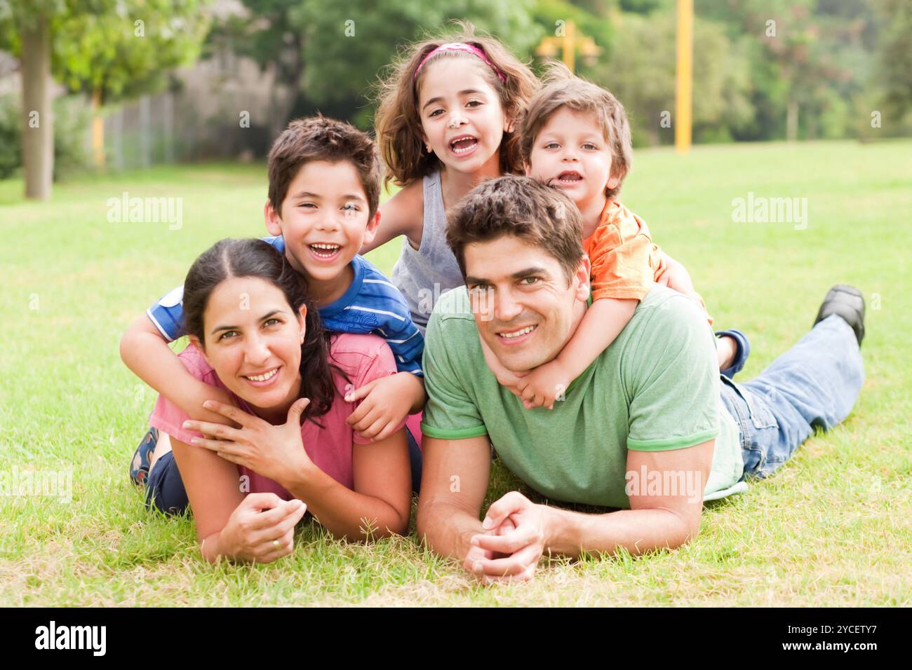 Happy family of five lying in the park and smiling at camera Stock ...