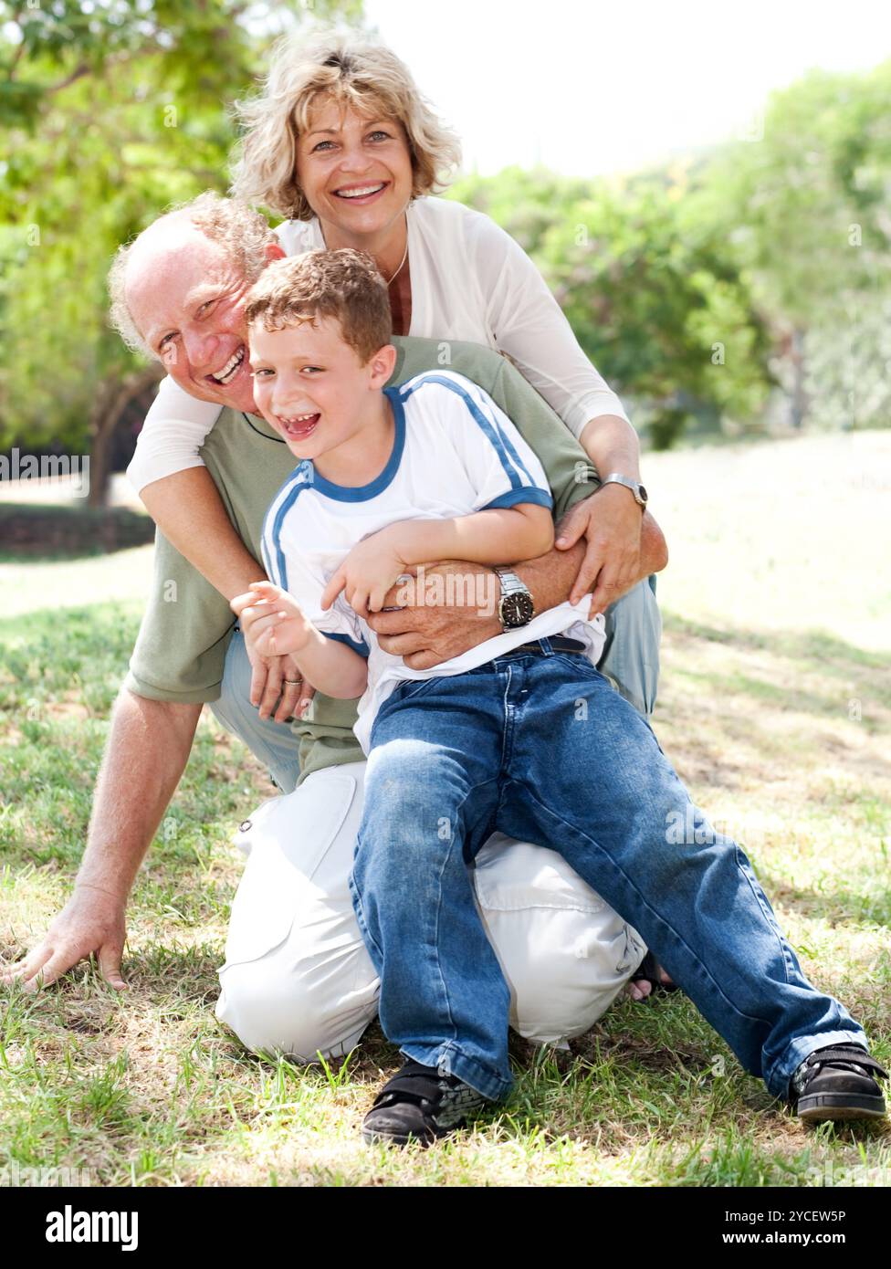 Grandparents playing with grandson in the park as they enjoy the sunny ...