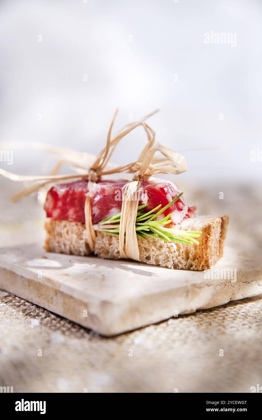Presentation of a snack of bread and salami Stock Photo - Alamy