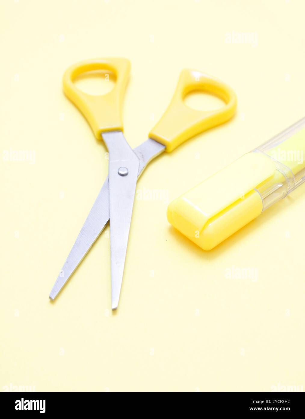 Yellow scissors and a marker Stock Photo - Alamy