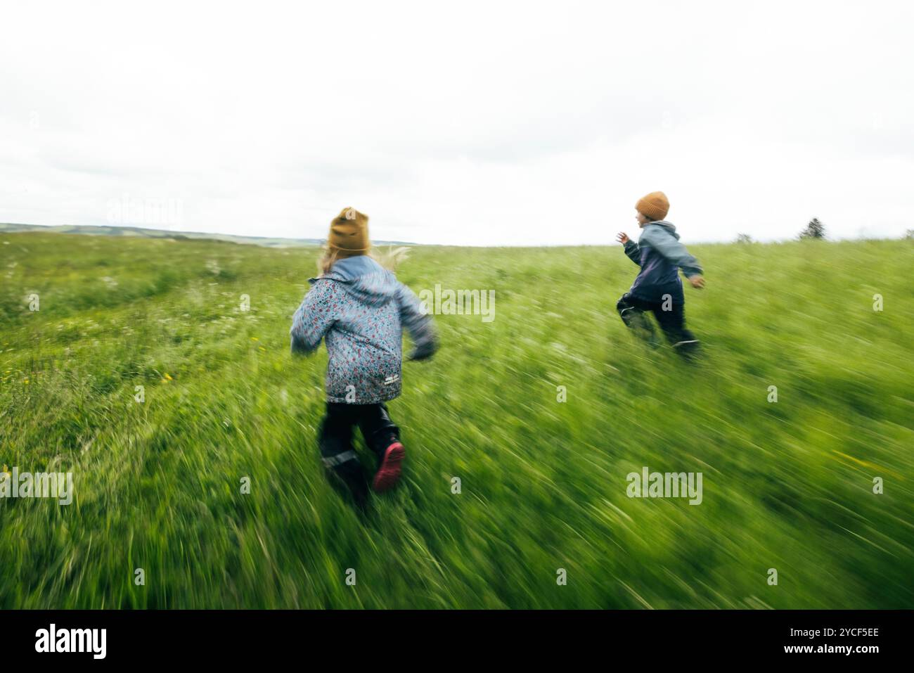Children running together across a meadow Stock Photo - Alamy