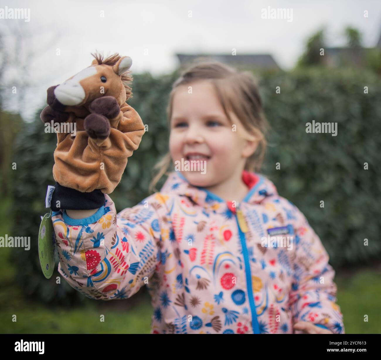 Portrait of a smiling girl with a hand puppet Stock Photo - Alamy