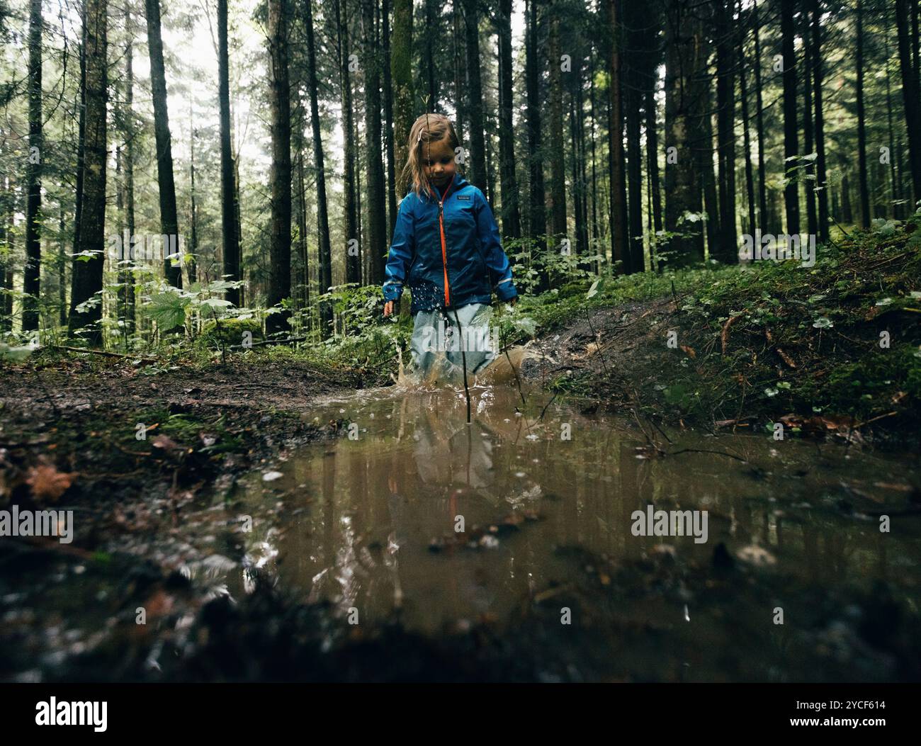 Girl jumps into a puddle Stock Photo - Alamy